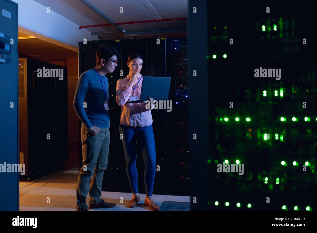 Diverse male and female engineers using laptop in computer server room Stock Photo - Alamy