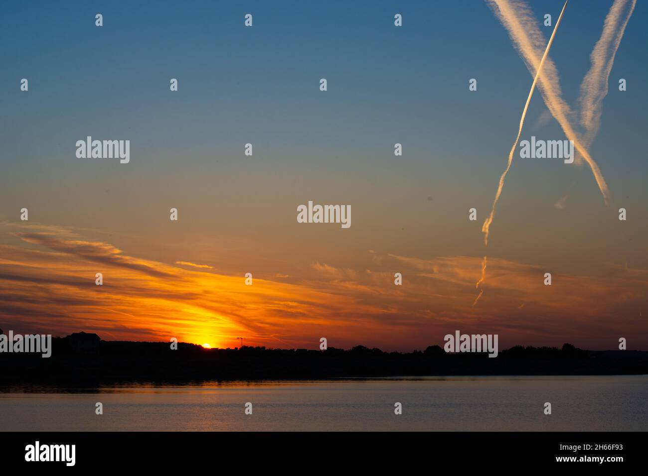 airplane trails at the sunset Stock Photo - Alamy