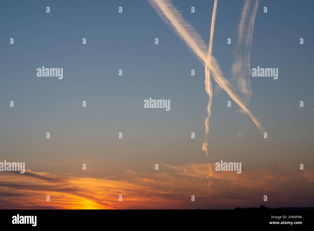 airplane trails at the sunset Stock Photo - Alamy
