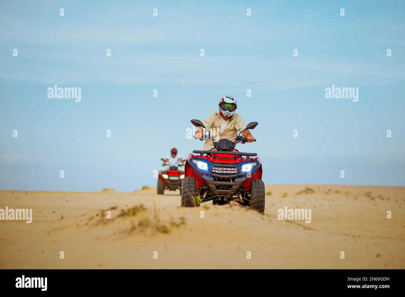 Two men in helmets ride on atv, action view Stock Photo - Alamy