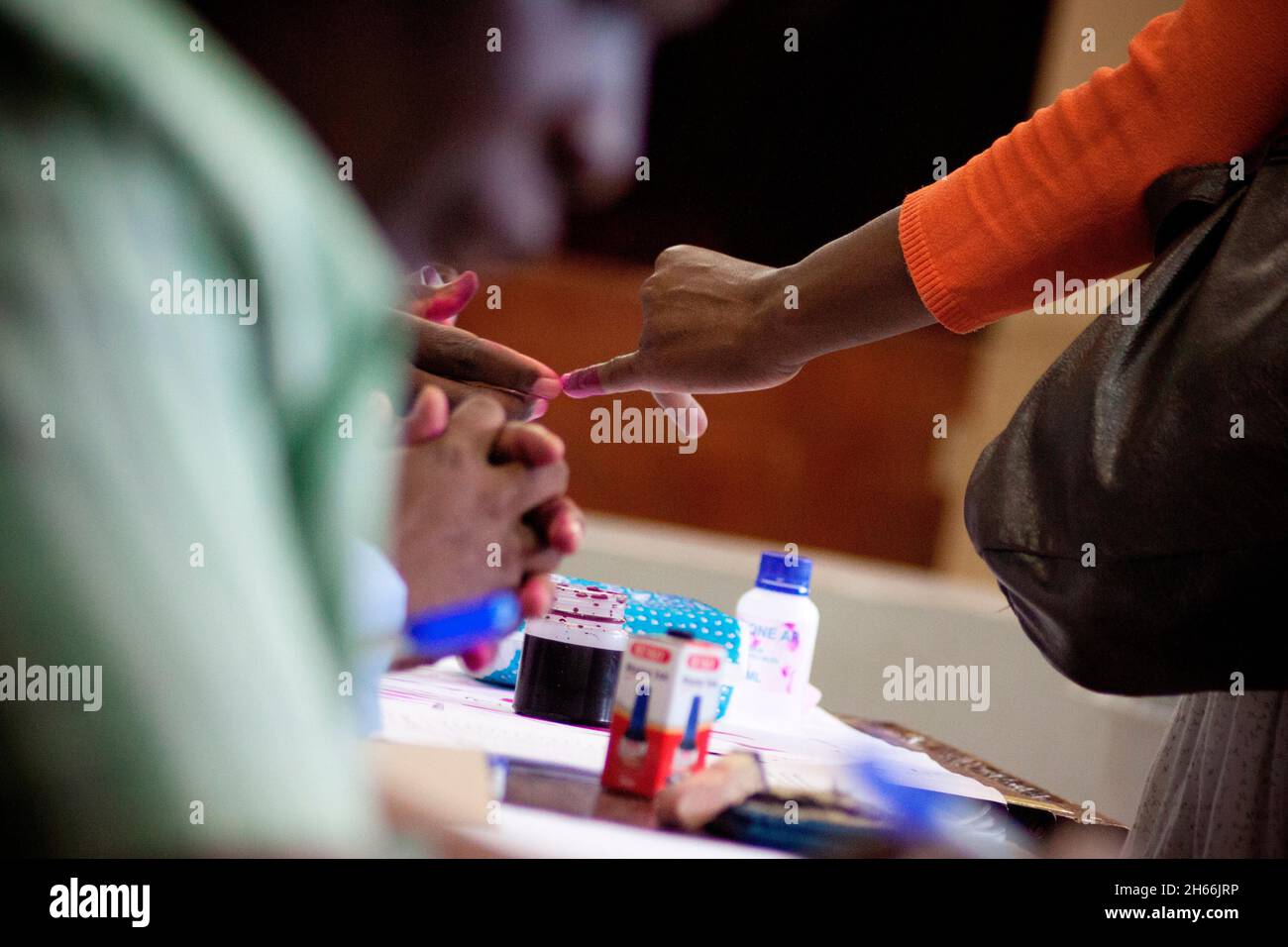 A voter's pinky finger is inked as a sign that they have already voted ...