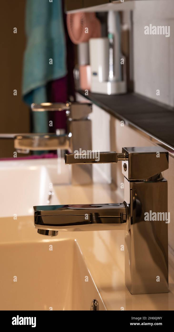 Bathroom interior with two chrome faucets and a white sink Stock Photo ...