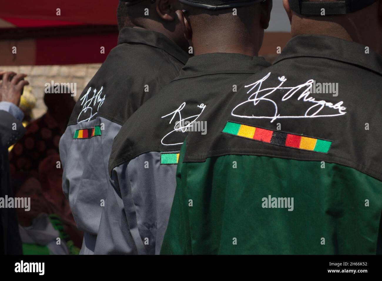 Young men are seen clad in overalls bearing President Robert Mugabe's ...