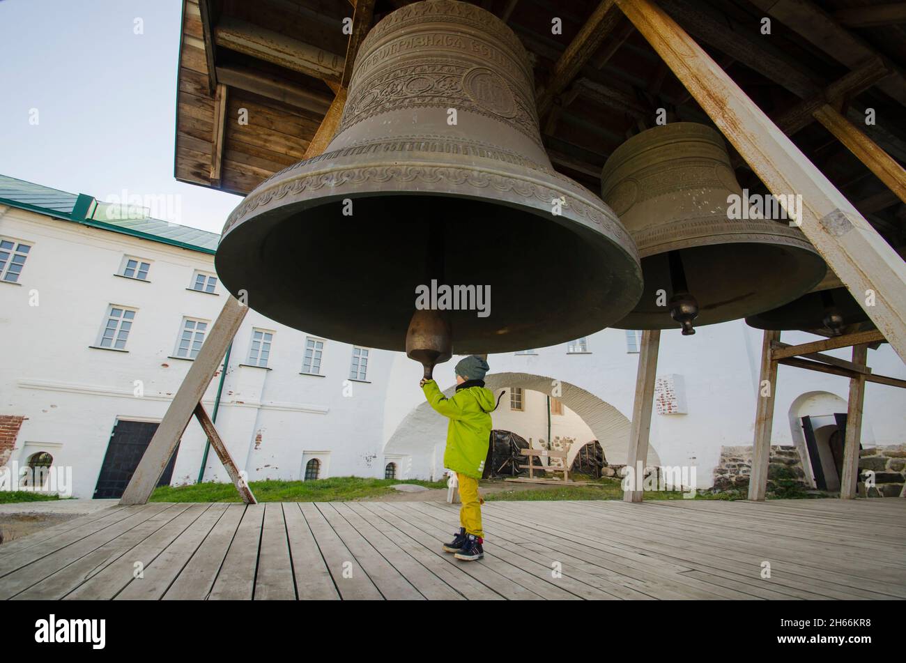 Little boy under a huge bell Stock Photo - Alamy