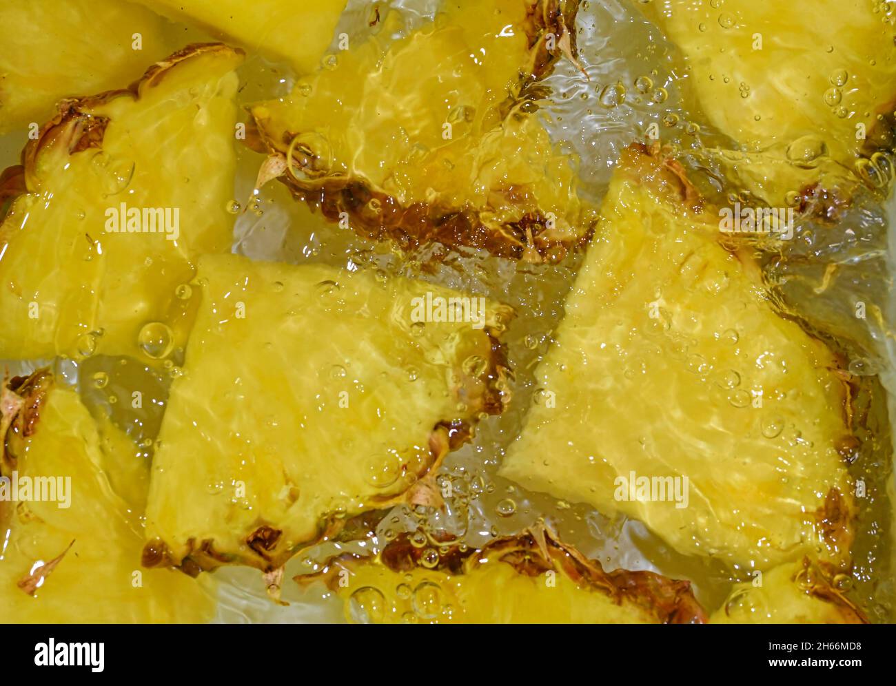 Slices of pineapple in water on white background. Pineapple close-up in ...