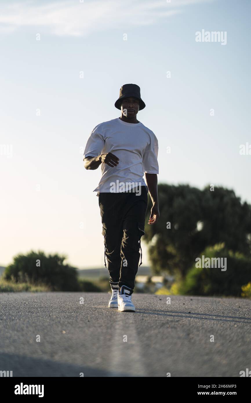Young cool black male in a street style outfit walking and posing ...