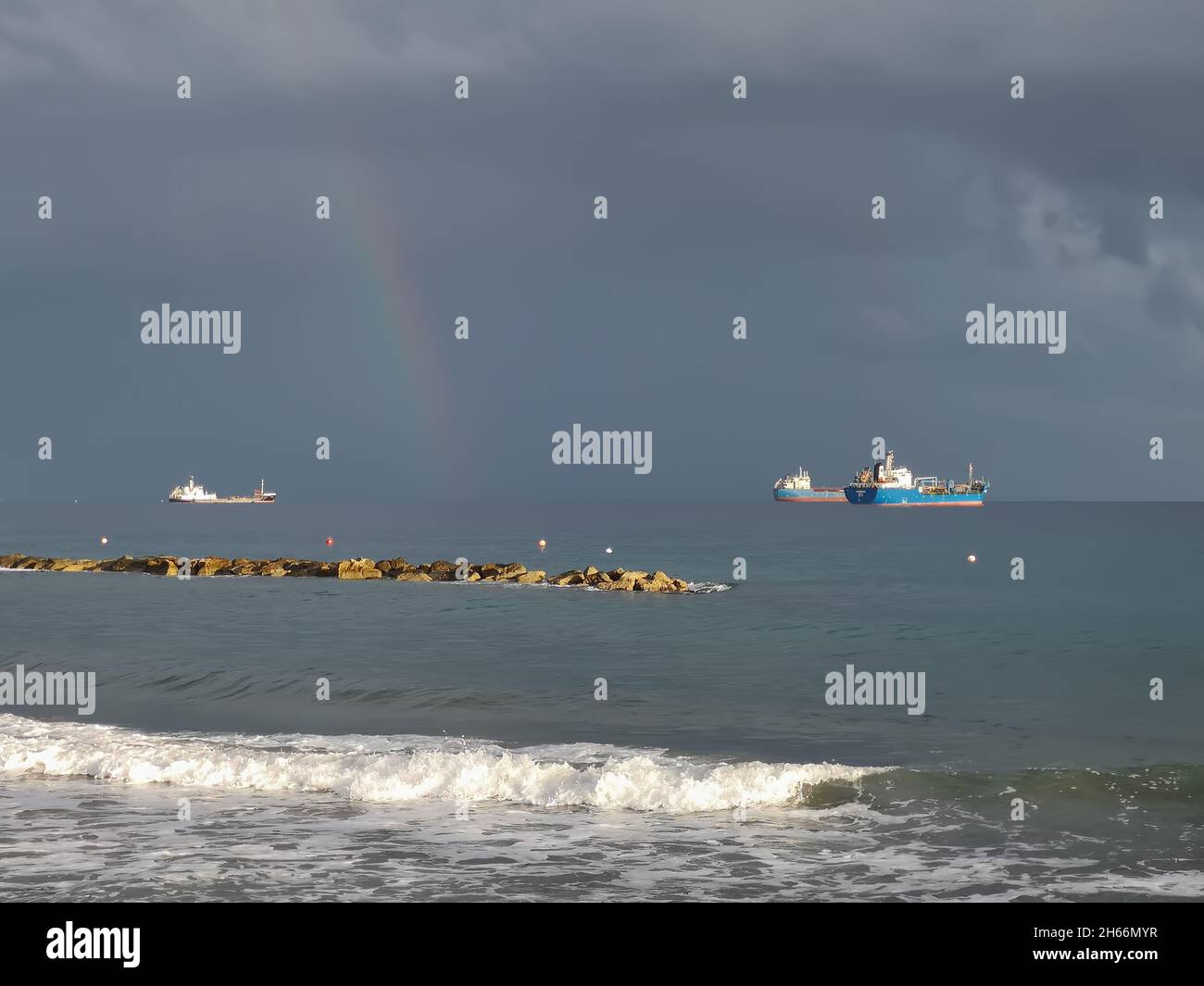 Rainbow over the Mediterranean Sea. Freighters on their way to the Port ...