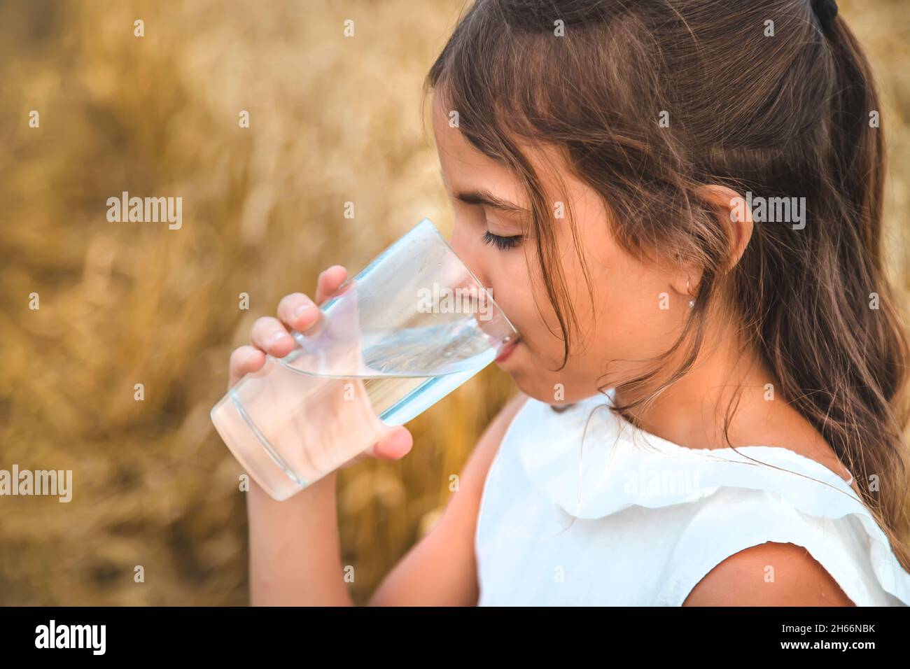 The child drinks water from a glass. Selective focus. Kid Stock Photo - Alamy