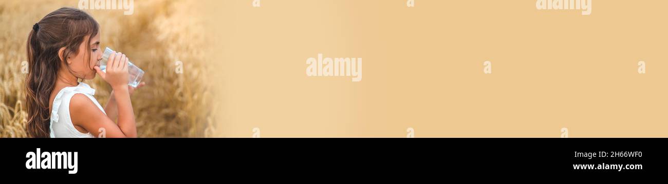 The child drinks water from a glass. Selective focus. Kid Stock Photo - Alamy