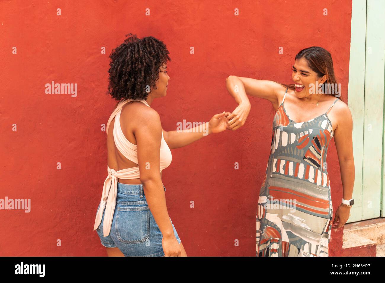 Two friends greeting each other after meeting in the street Stock Photo ...
