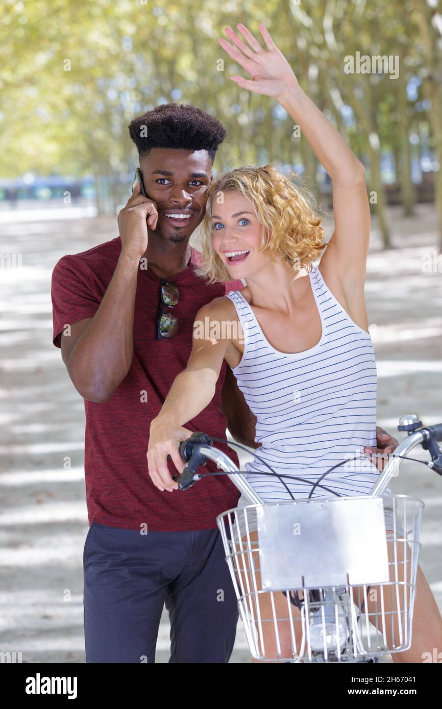 happy young friends with bicycles waving Stock Photo - Alamy