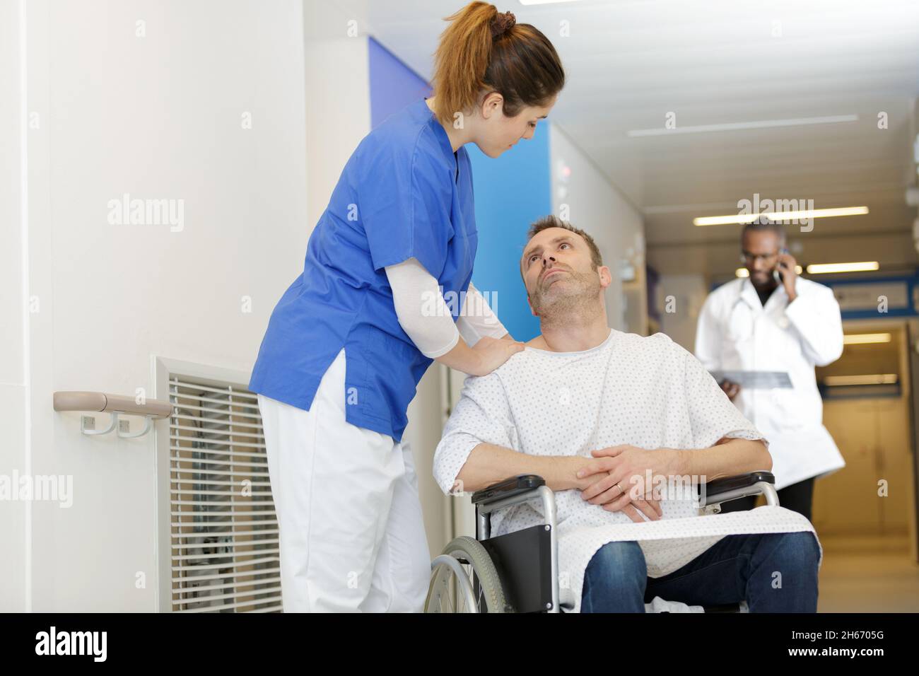 nurse reassuring patient in a wheelchair Stock Photo - Alamy