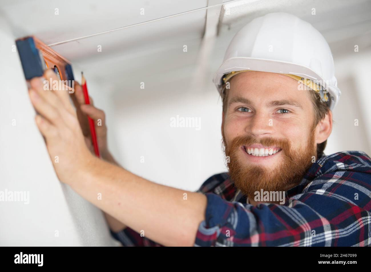 happy smiling constructor holding construction level Stock Photo - Alamy