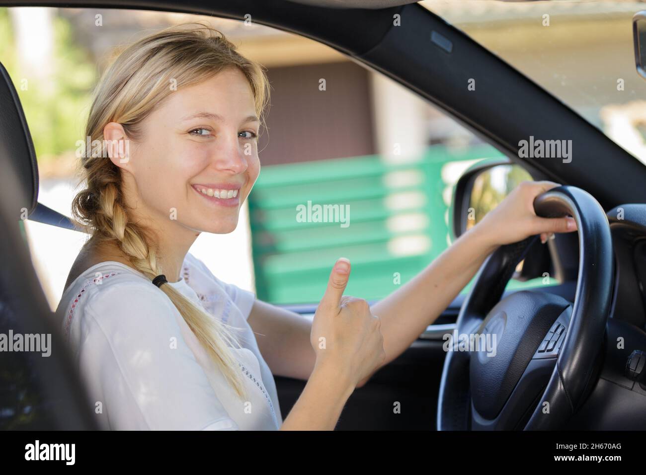 young female driver showing thumbs up Stock Photo - Alamy