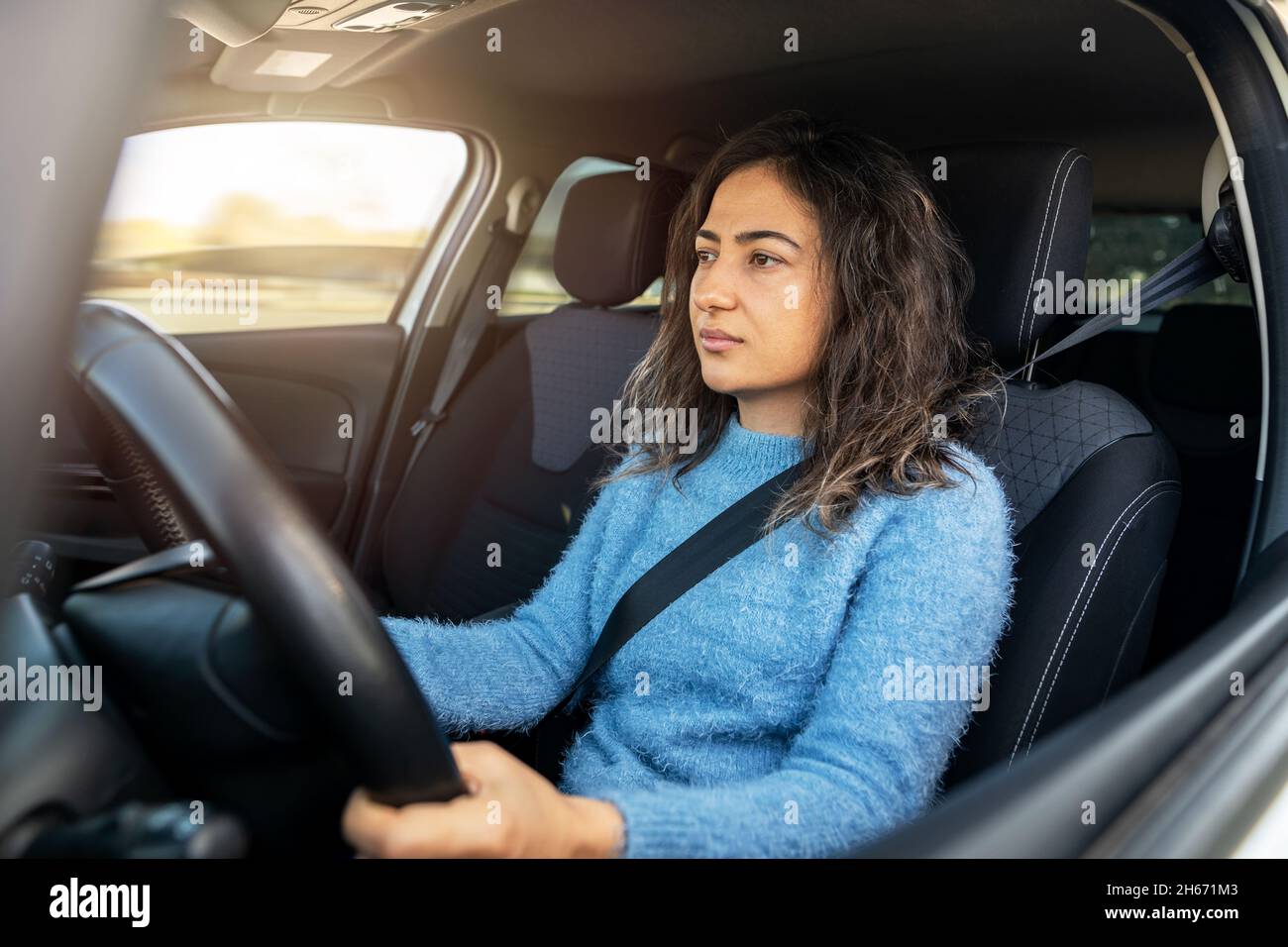 Young woman driving car on the road. Driver licence and driving safety ...