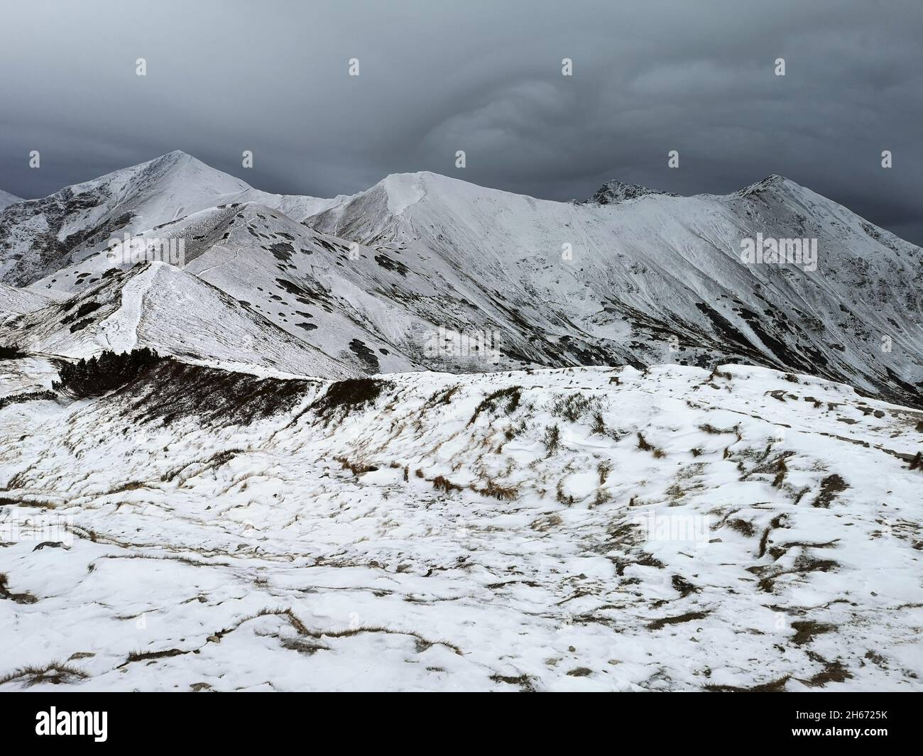 Snow-covered mountain range on a gloomy day Stock Photo - Alamy