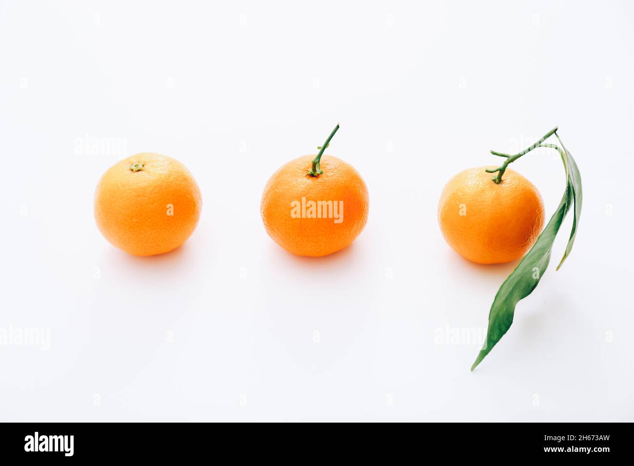 Fresh clementines in row on white background Stock Photo - Alamy