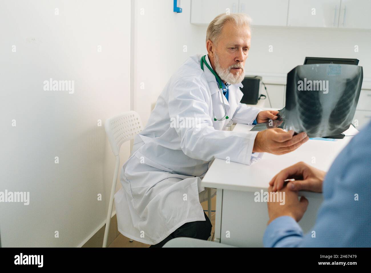 View from back of unrecognizable male patient listening mature adult ...