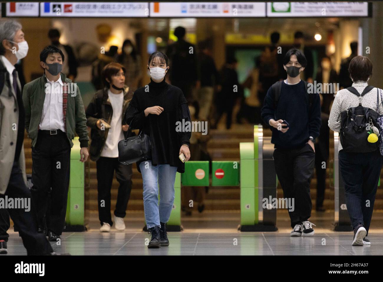 Tokyo, Japan. 28th Oct, 2021. Passengers with face masks walk through ...