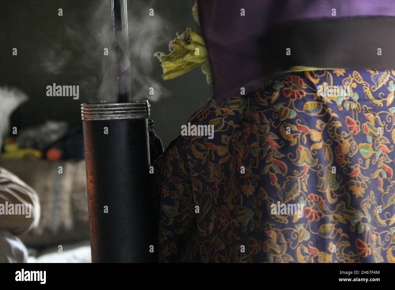 Nepali woman churning traditional Tibetan butter tea, also known as Po ...