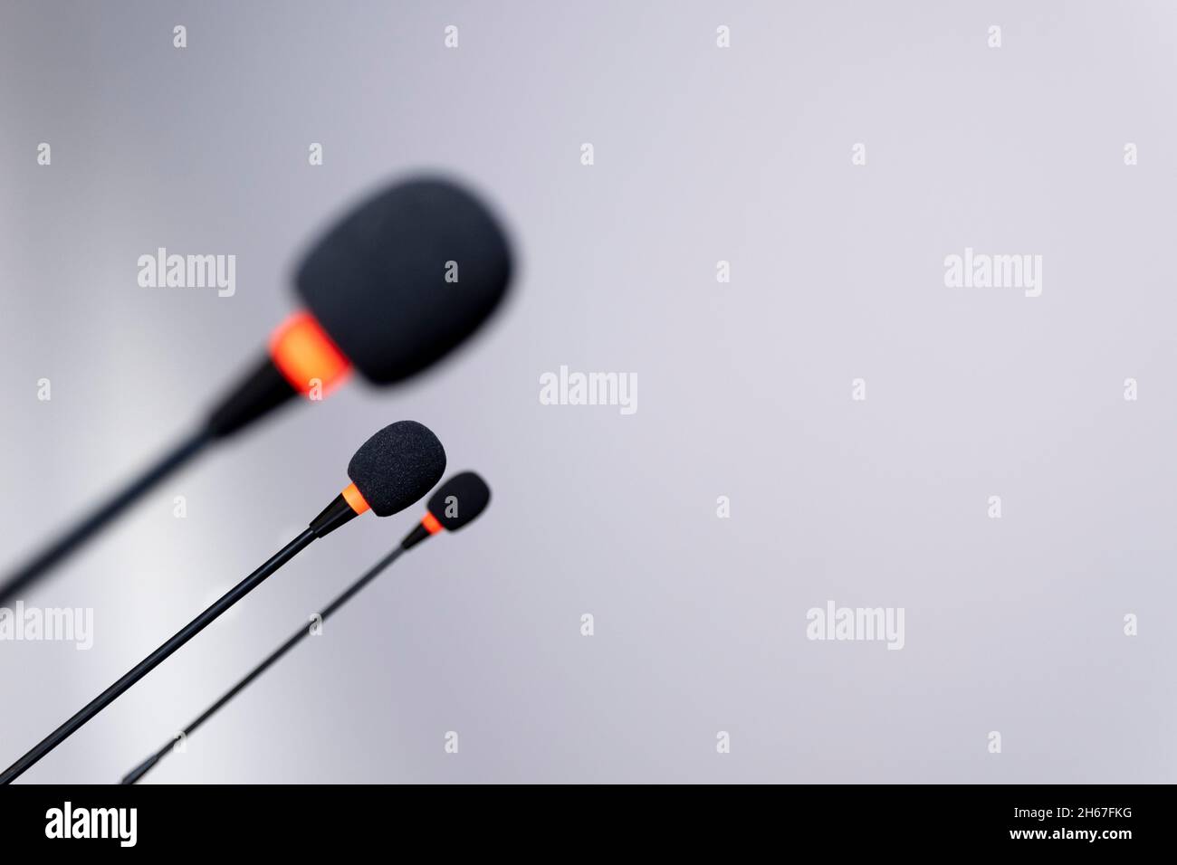 Small microphones on long stands with red indicators in the background ...