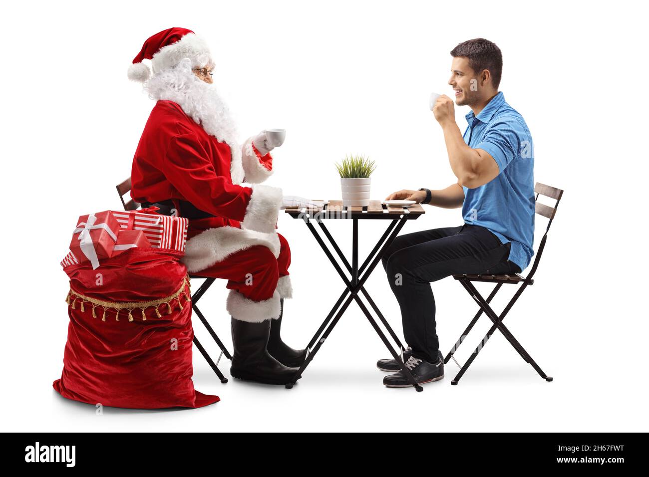 Santa Claus drinking coffee with a casual young man at a cafe isolated ...