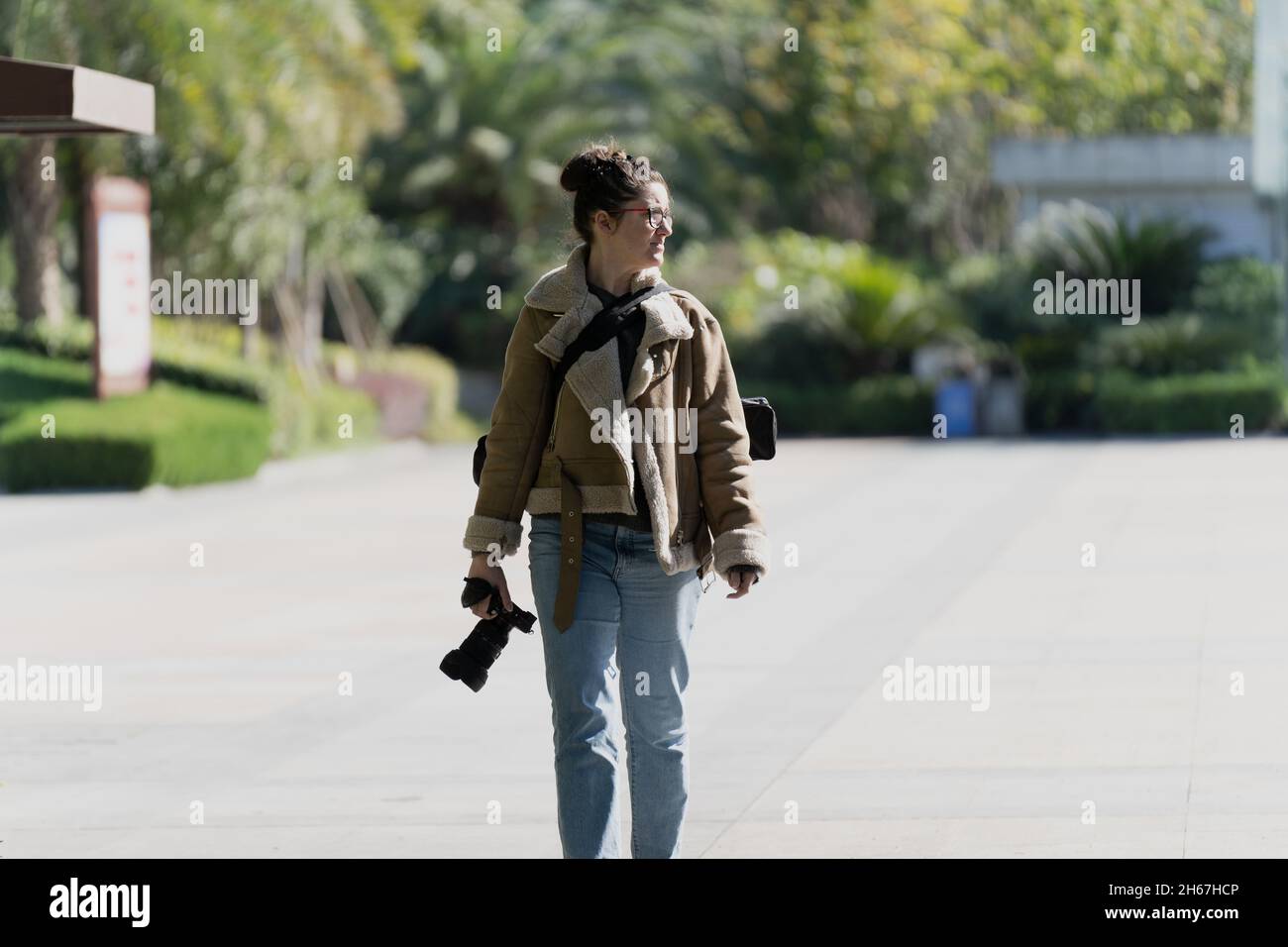 A professional female photographer taking a photo sideways Stock Photo ...