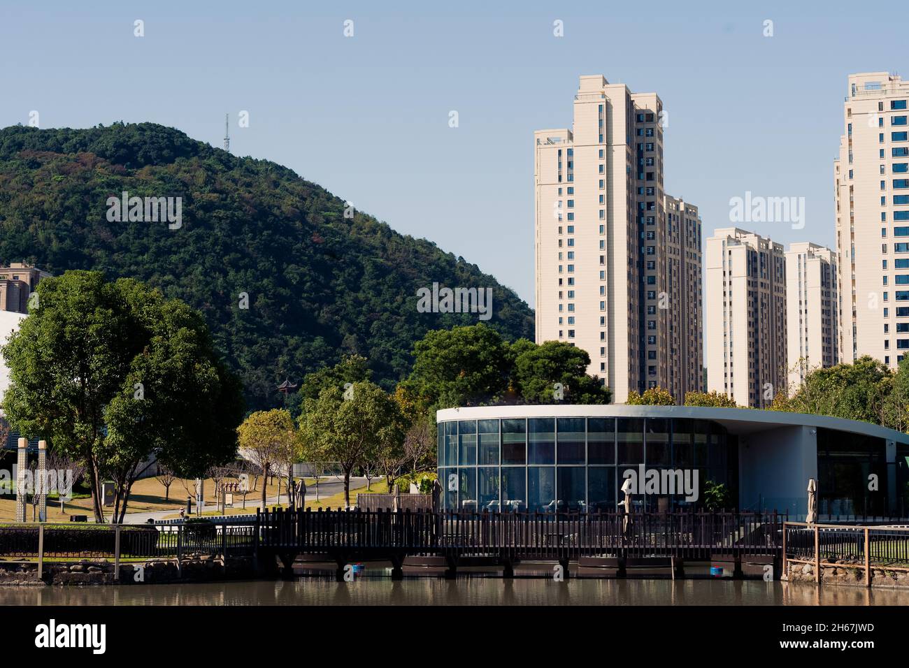A modern looking building in a park with mountains and residential ...