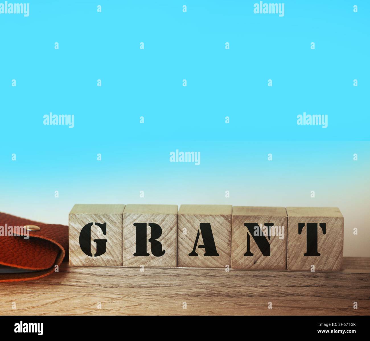 the word GRANT on building blocks and brown leather wallet Business ...