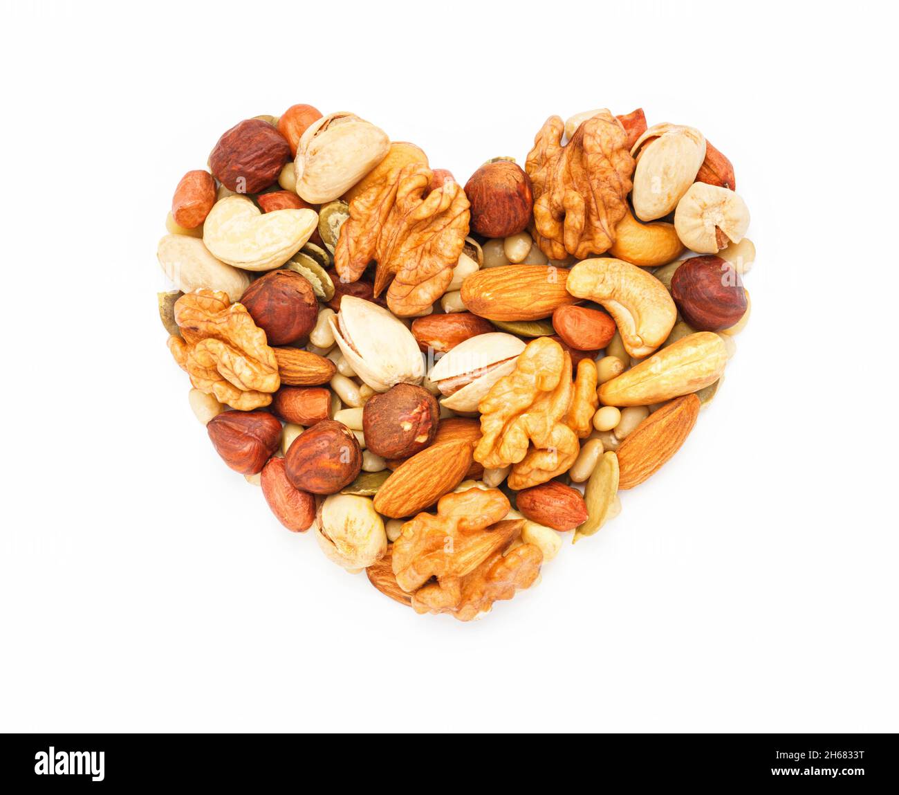 Heart shaped nuts and seeds isolated on white background close-up, flat ...