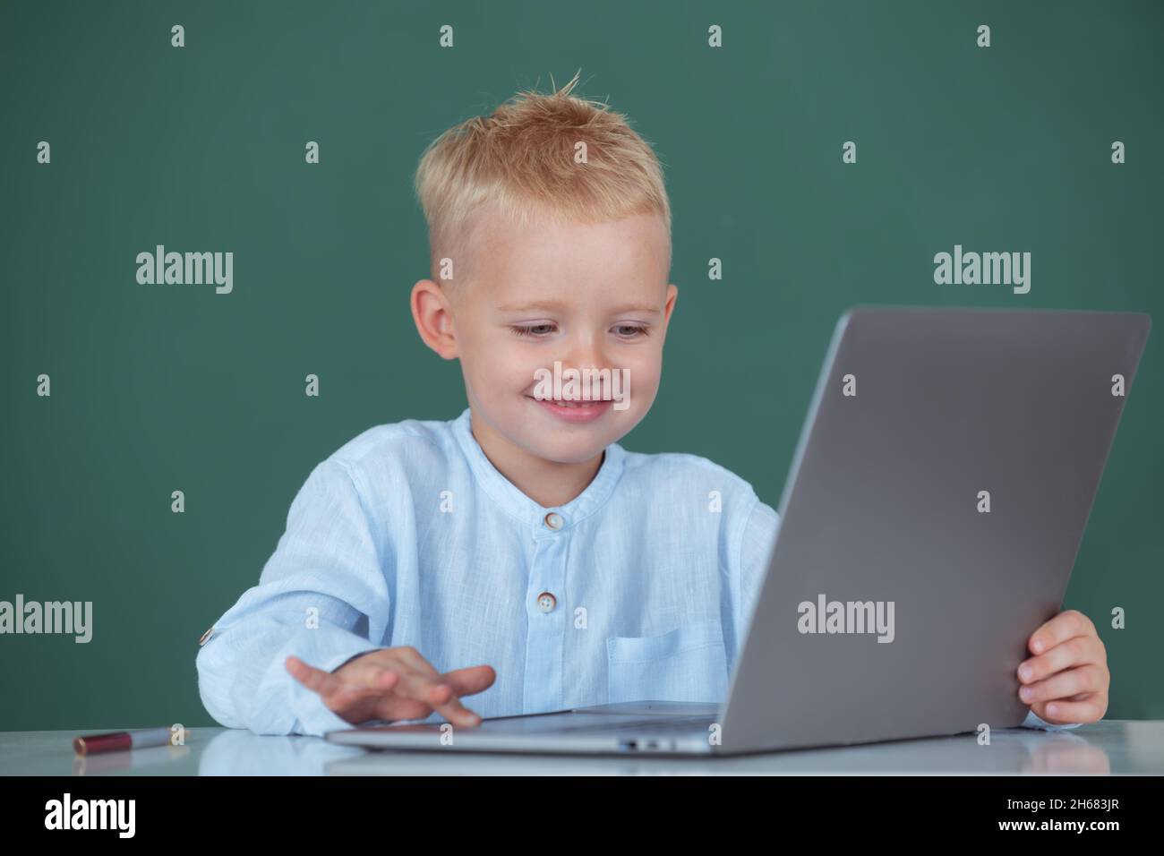 Cute smiling child using laptop computer, kid boy studying through ...