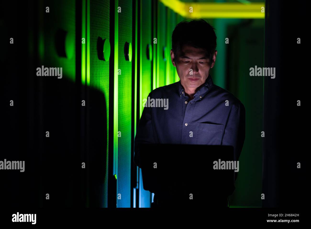 Asian male engineer using laptop in computer server room Stock Photo ...