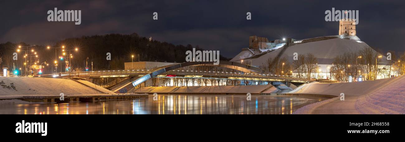 A beautiful night view of Mindaugas Bridge over a river next to ...