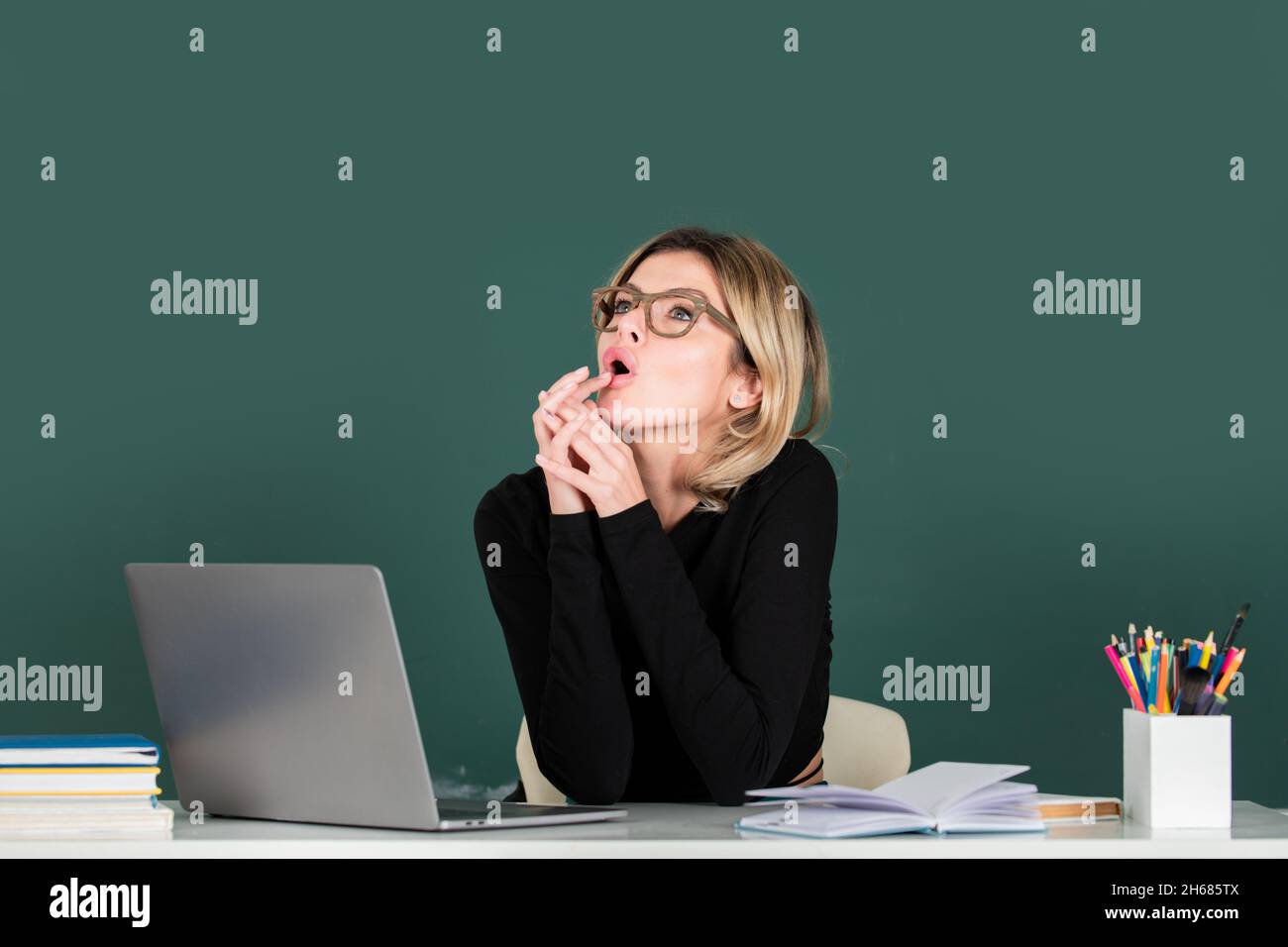 Teacher in classroom at university or college. Female student on board ...