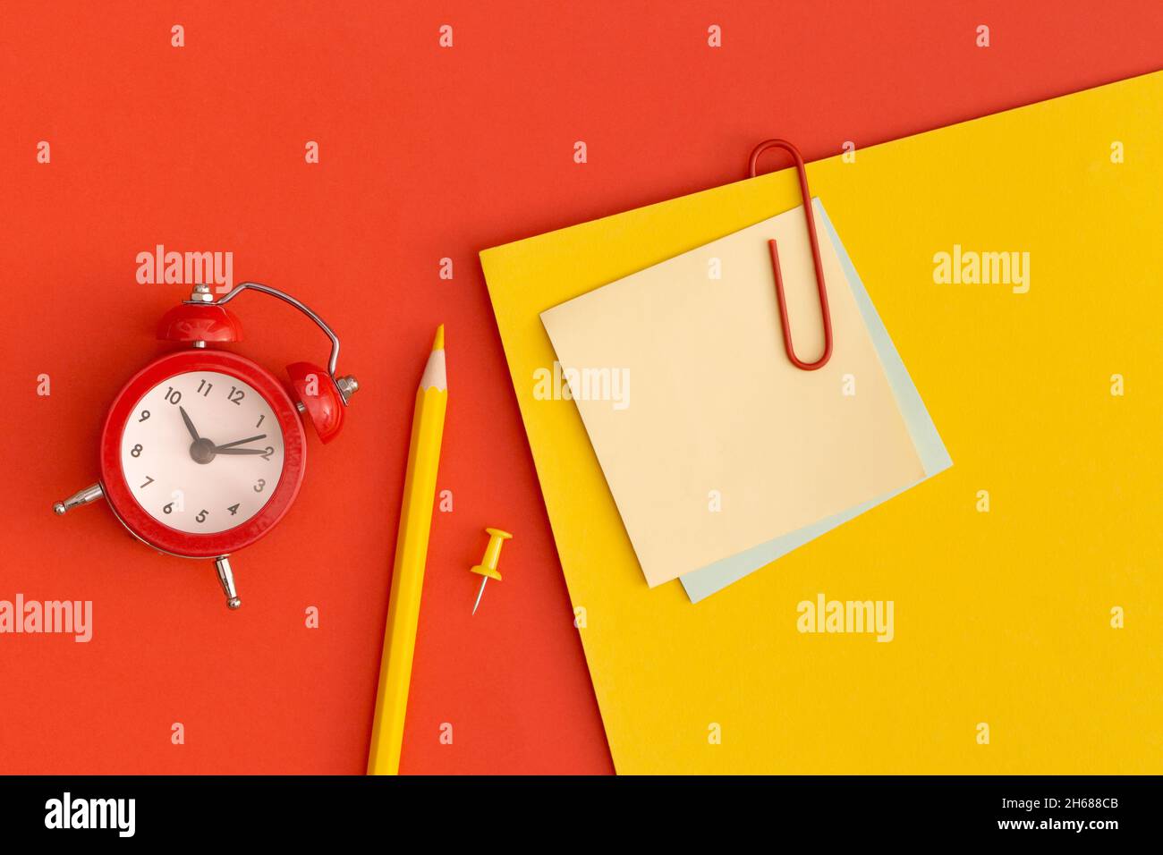 Red alarm clock and sticky notes with space for text on red background ...