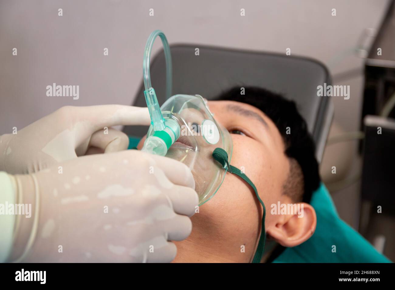 Closeup hands of doctor and assistant holding oxygen mask with patient ...