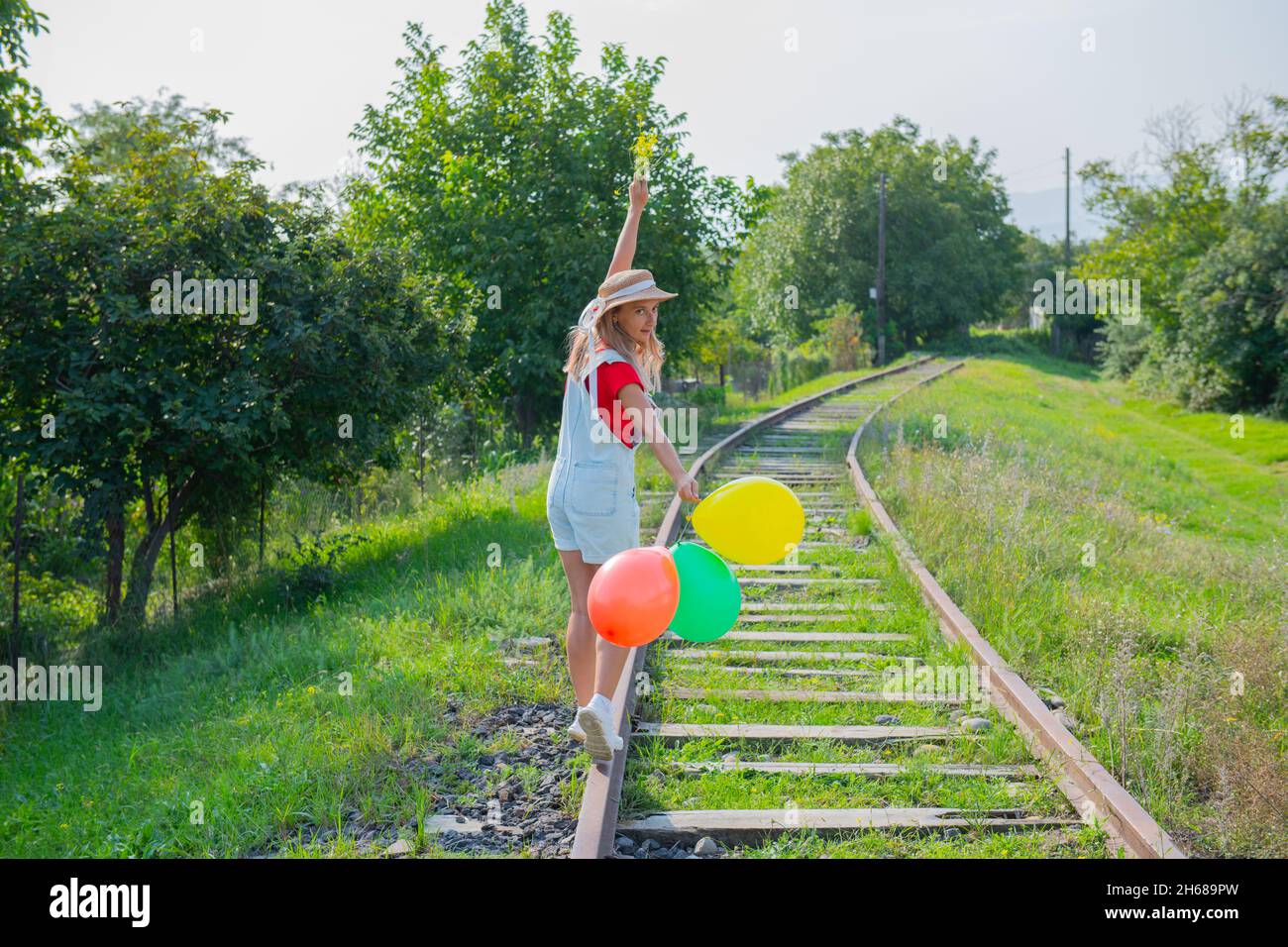 woman walking with balloons on the railroad Stock Photo - Alamy