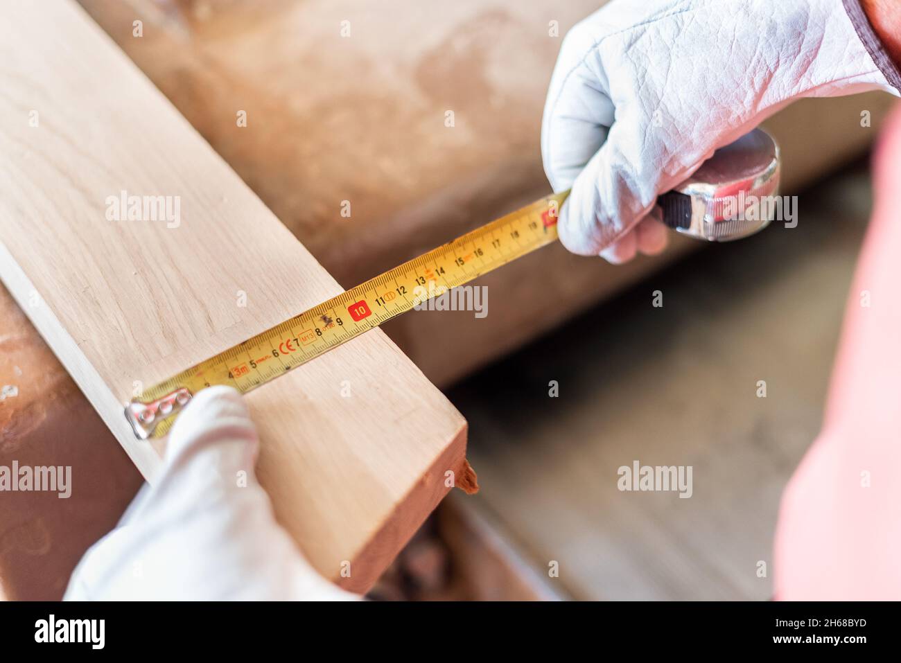Person measuring a wooden plank with a meter Stock Photo - Alamy