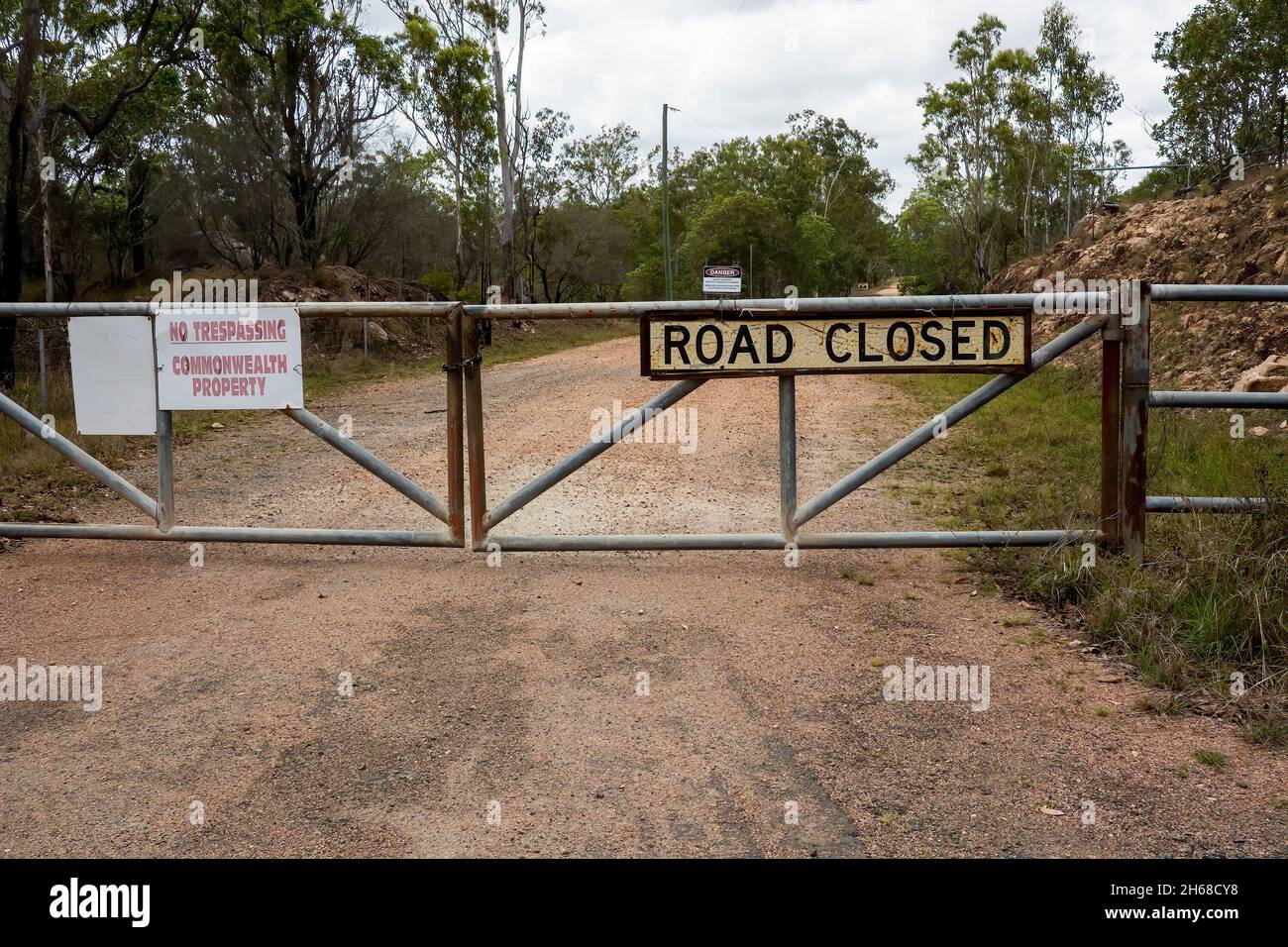 Road closed signage on a steel gate across a dirt road to discourage ...