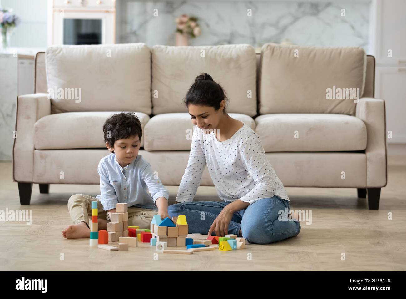 Happy Indian mom helping preschool son to build toy towers Stock Photo ...