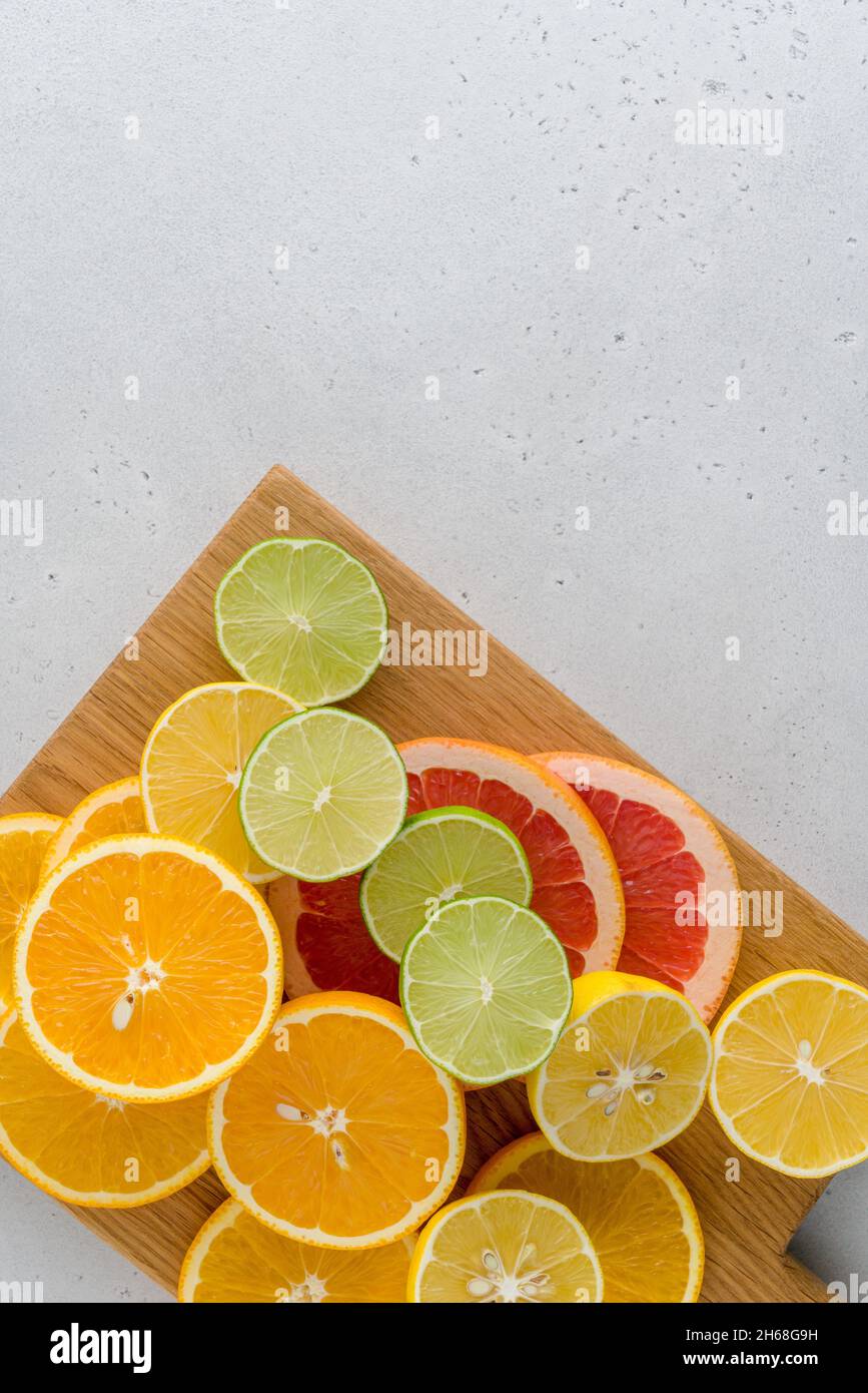 Exotic citrus composition on chopping board. Many juicy halved lemons ...