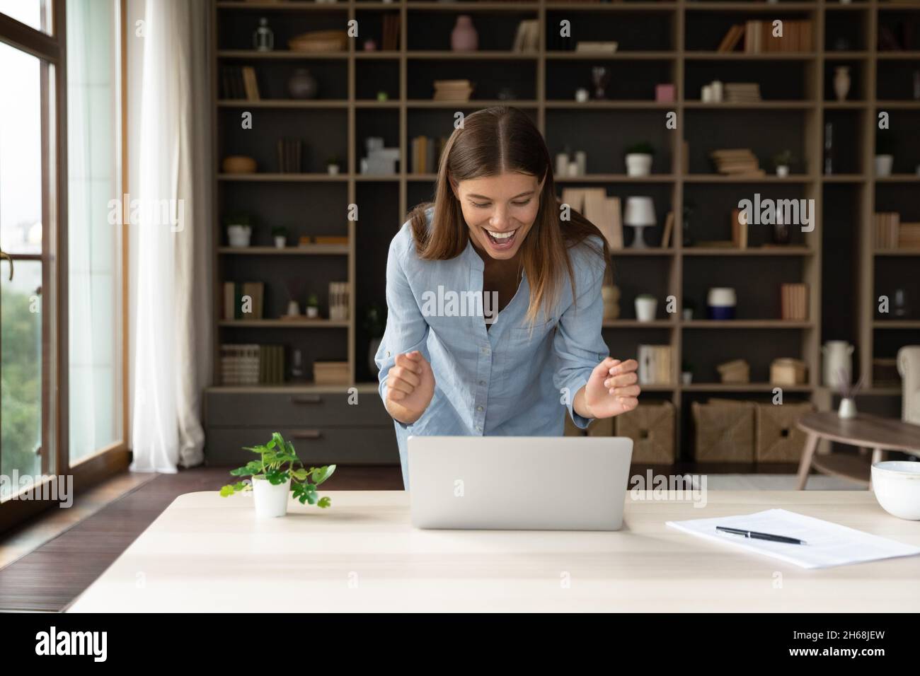 Happy beautiful young woman laughing looking at computer screen Stock ...