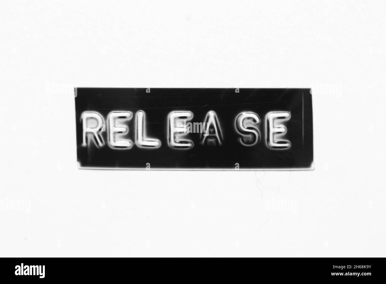 Black color banner that have embossed letter with word release on white ...