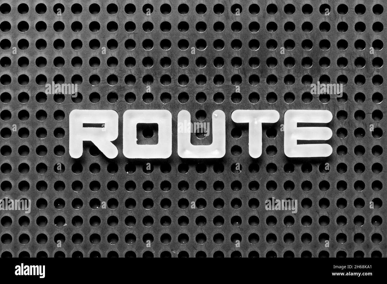 White alphabet letter in word route on black pegboard background Stock ...