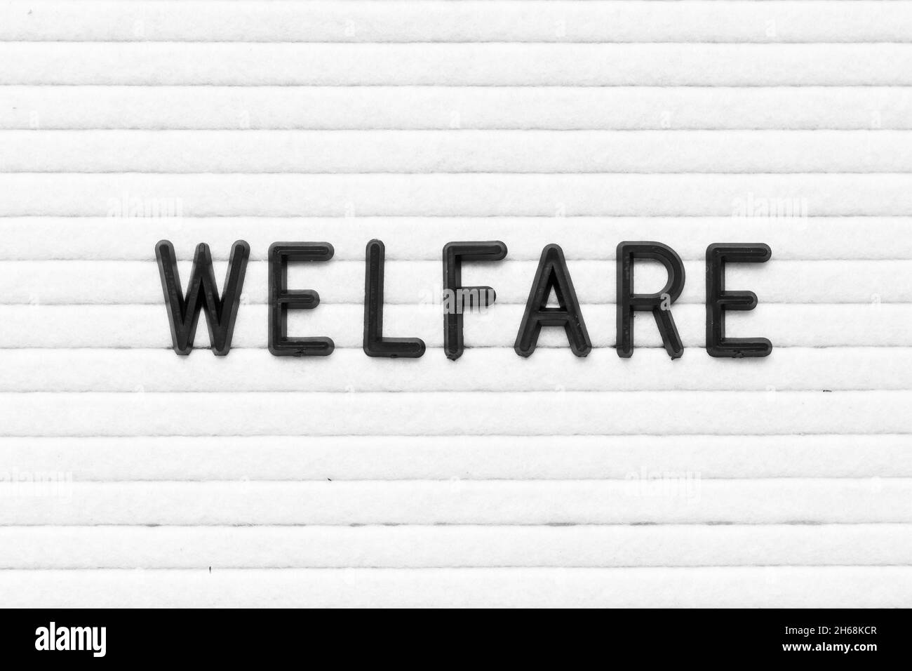 Black color letter in word welfare on white felt board background Stock ...
