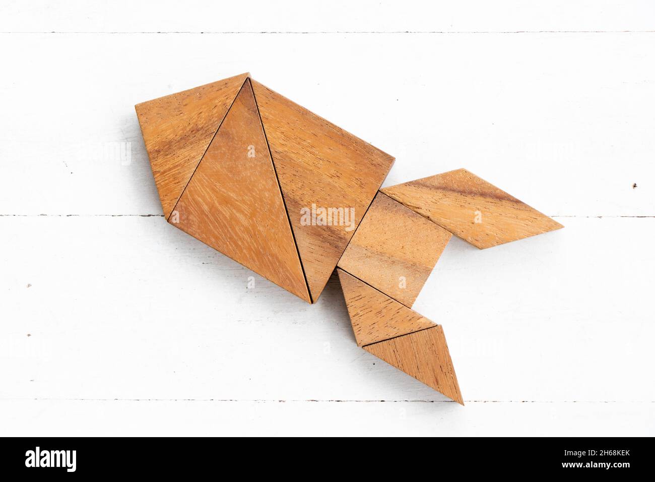 Wood tangram puzzle in rocket or missile shape on white wood background ...