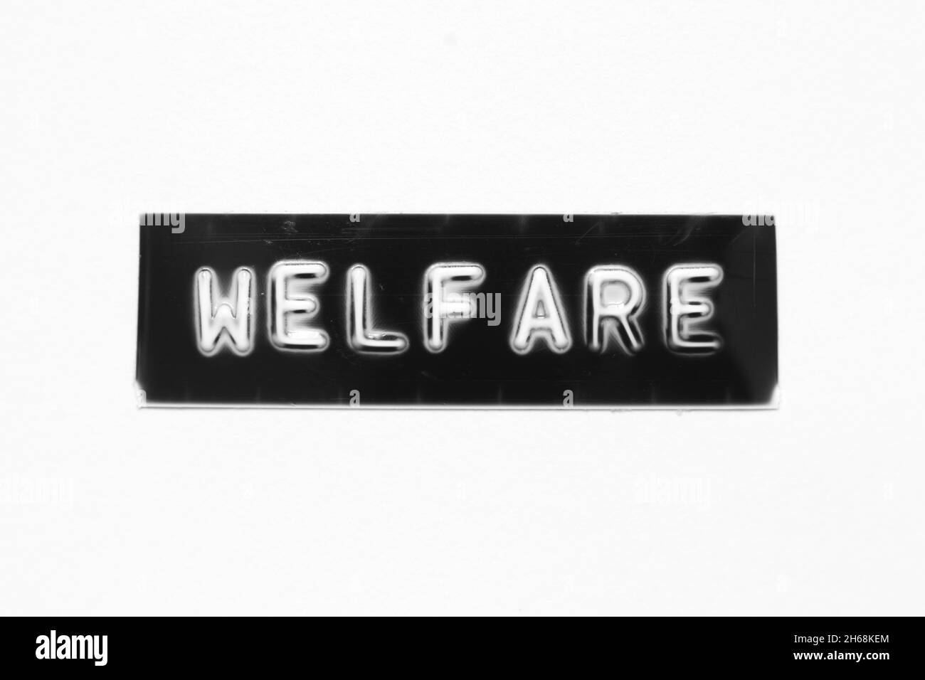 Black color banner that have embossed letter with word welfare on white ...