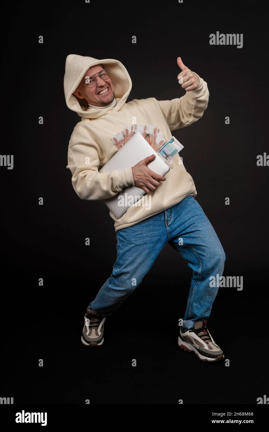 Successful business. Young happy man dancing holding bundles of hundred ...