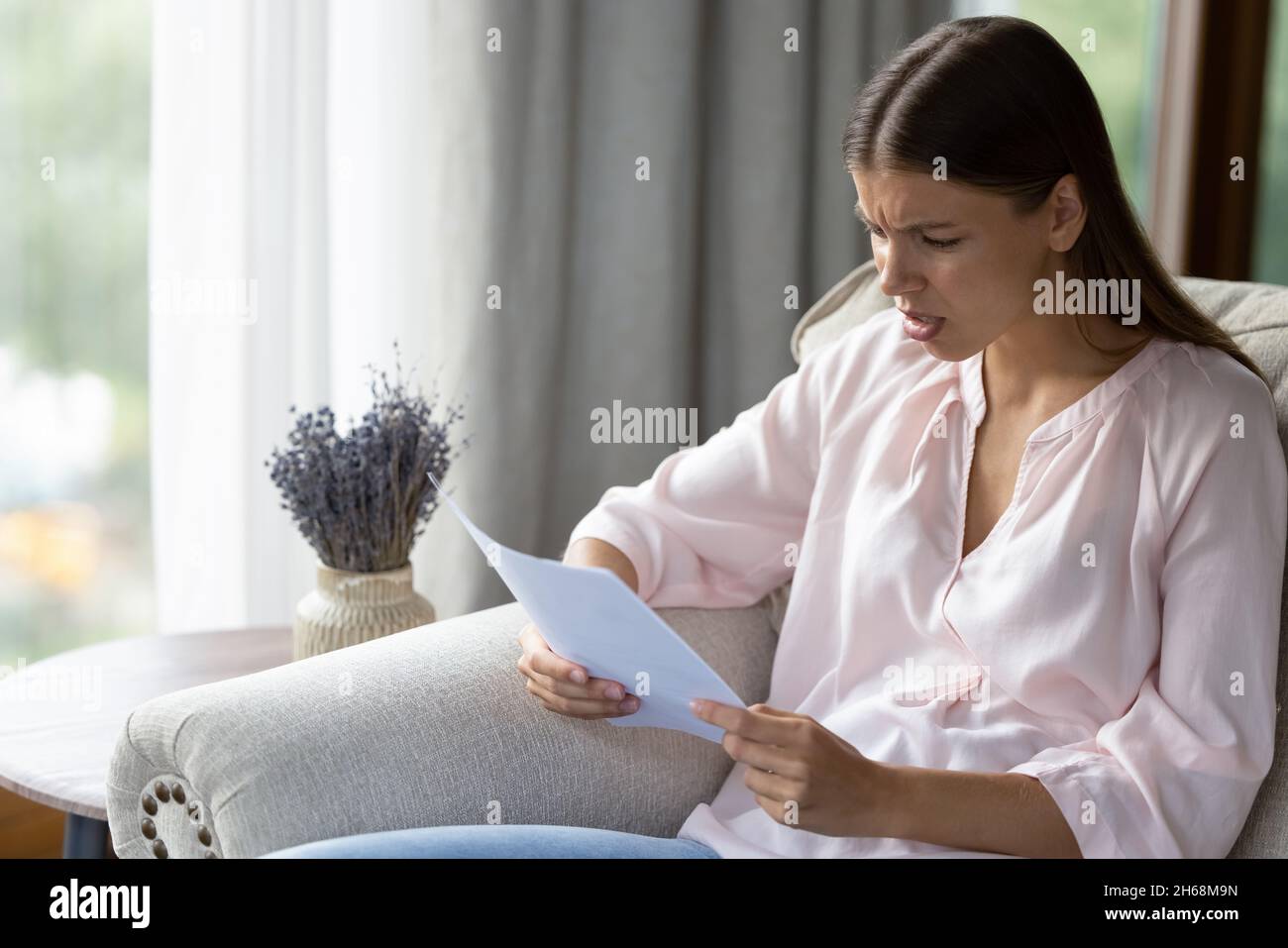 Stressed young woman reading letter with bad news Stock Photo - Alamy