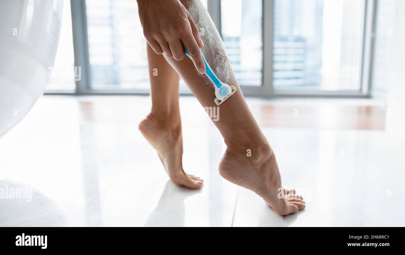 Young unrecognizable woman using safety razor shaving legs Stock Photo ...